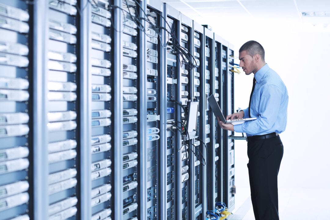Young it engeneer in datacenter server room - Cablecom Ltd